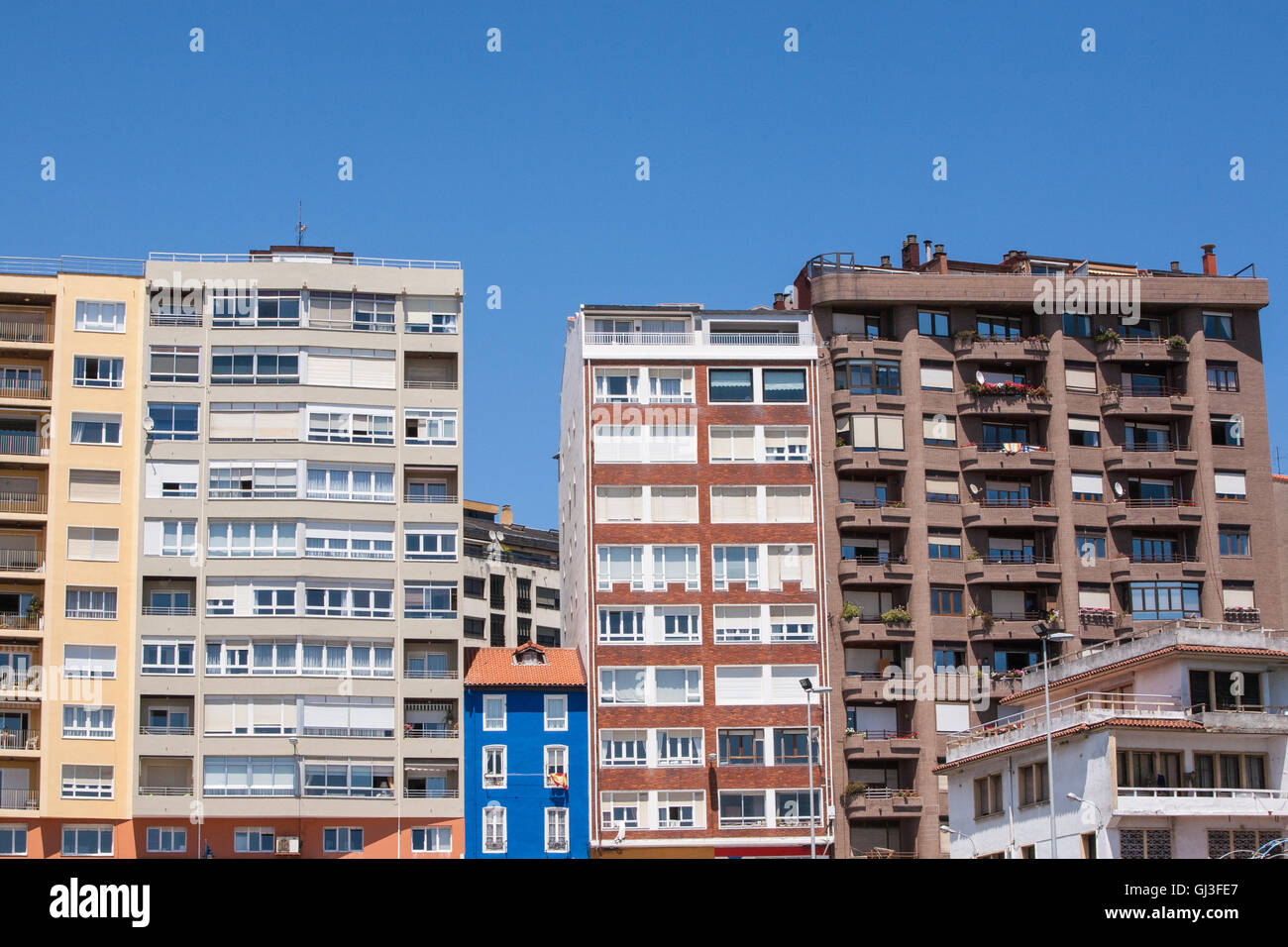 Colourful small short house in between large apartment buildings in ...