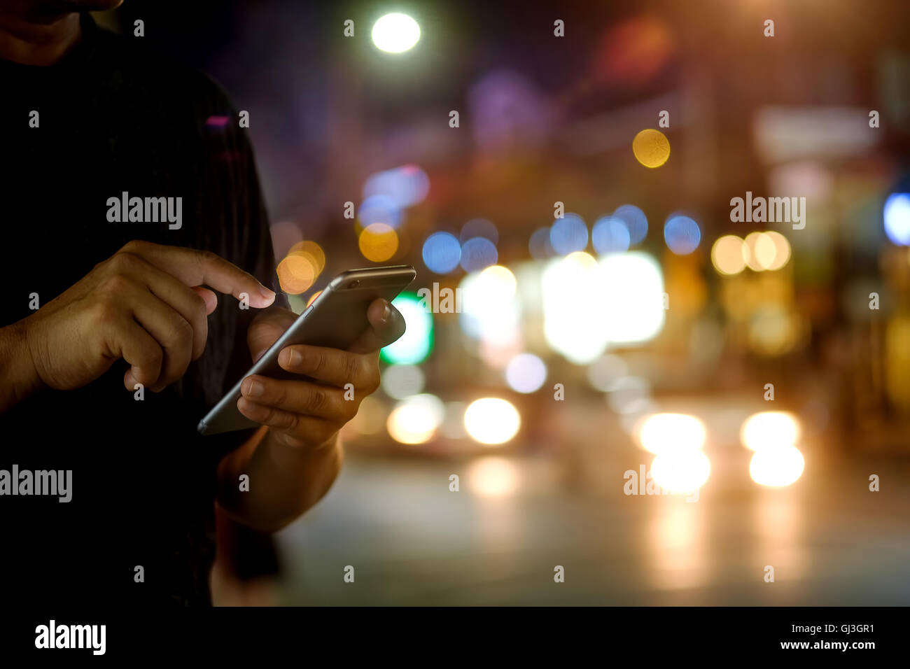 Young man with smart phone at night urban Stock Photo - Alamy