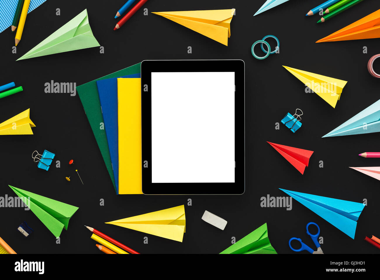 Blank tablet with paper, origami planes on the black background. Back ...
