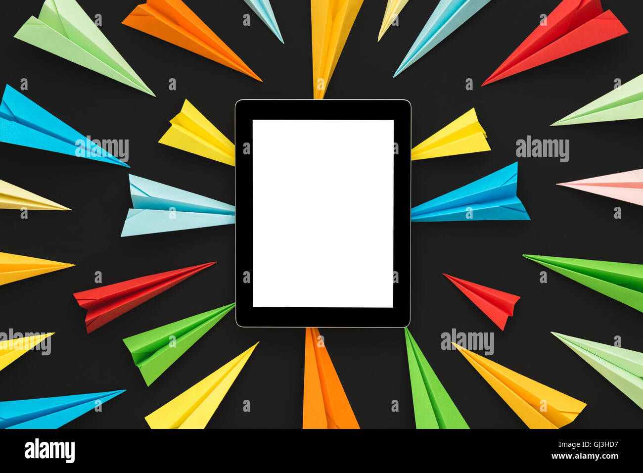 Multicolor paper, origami planes with tablet on the black background ...