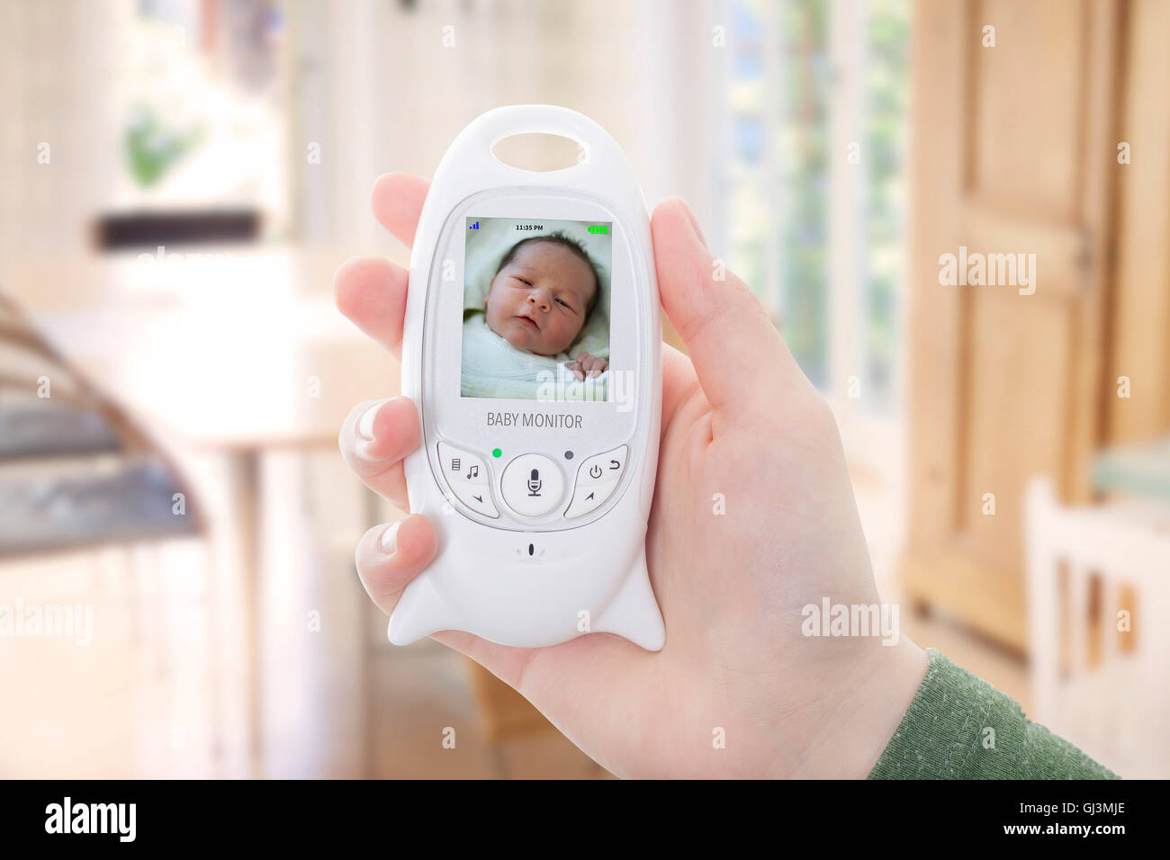 Mother or father checking baby through baby monitor Stock Photo - Alamy