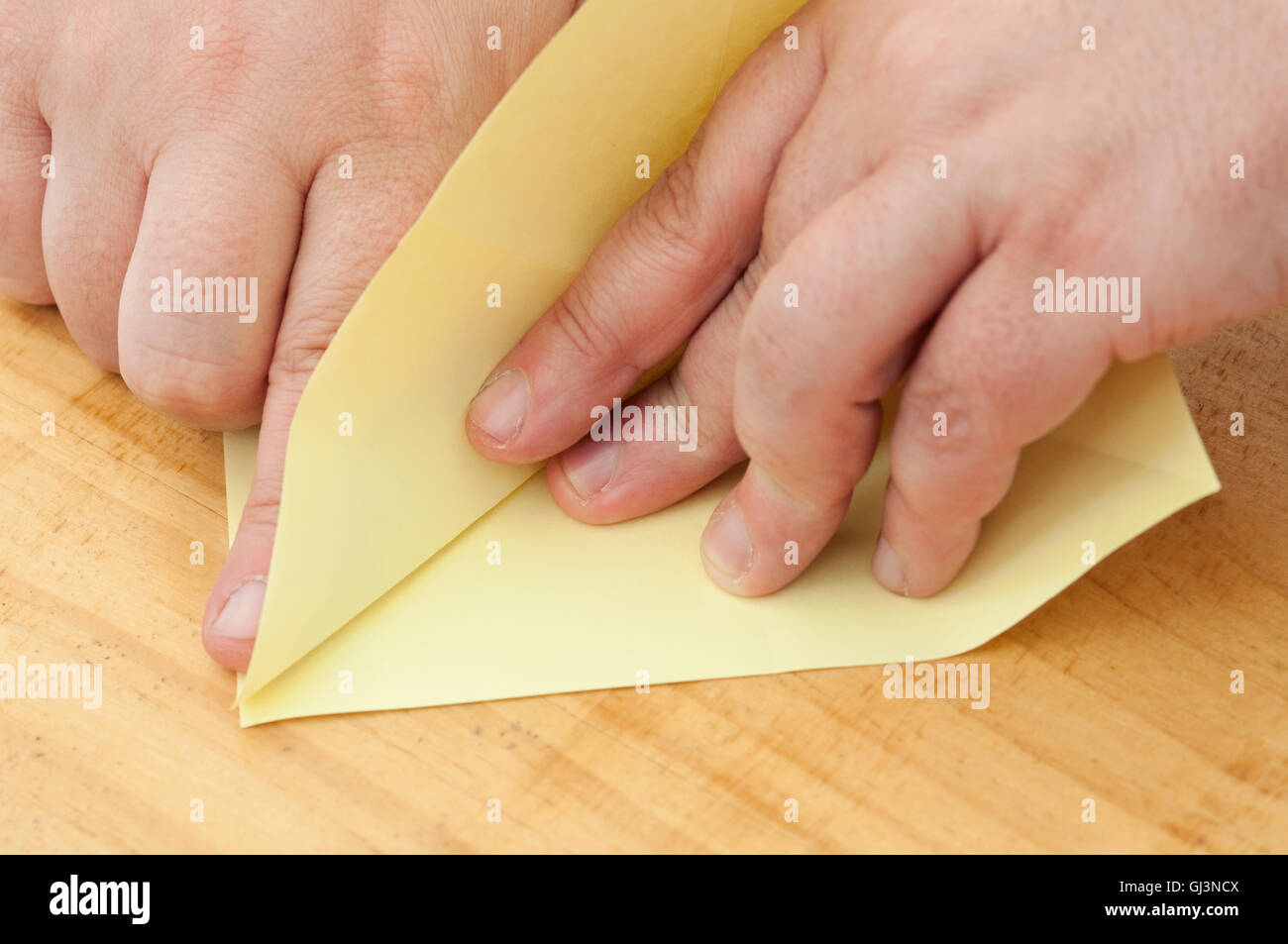 Hands Folding an Origami Stock Photo - Alamy