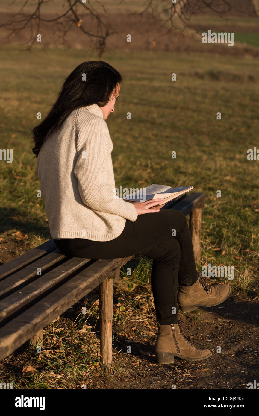 A girl reading a book in autumn Stock Photo - Alamy