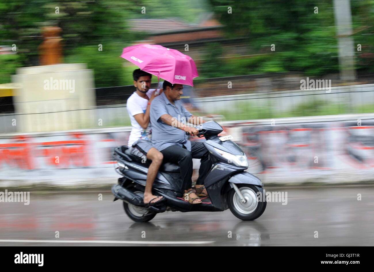 Allahabad, India. 12th Aug, 2016. People ride scooty during heavy rain ...