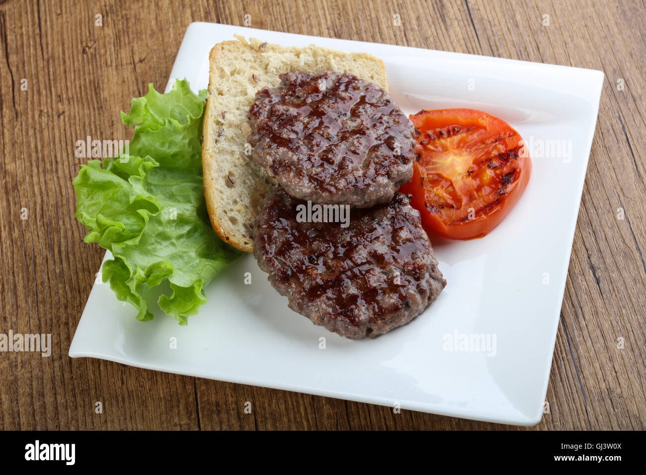 Grilled burger cutlet with bread and tomato Stock Photo - Alamy