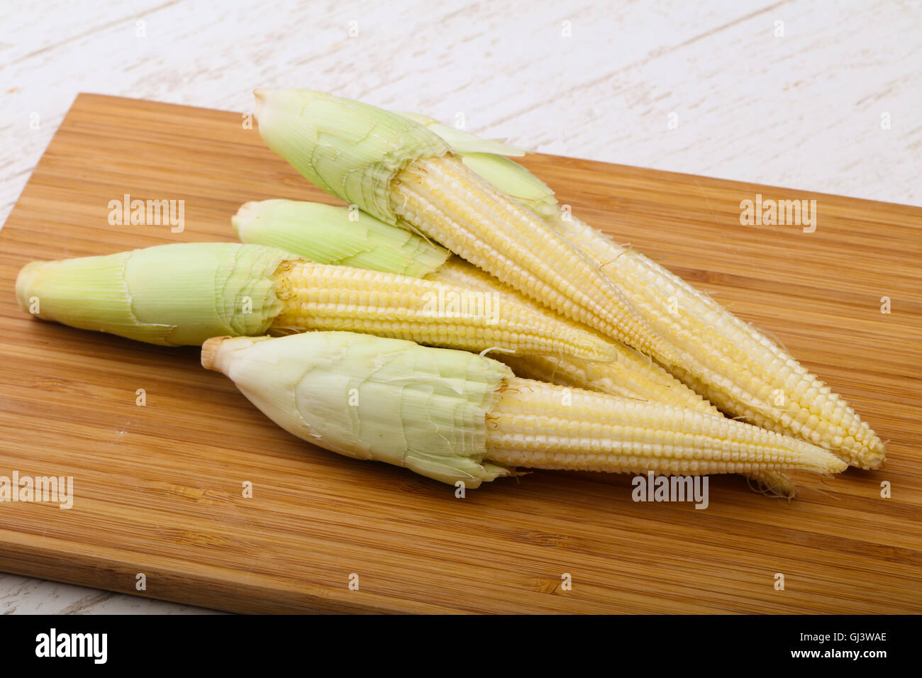 Fresh baby corn heap on the wood background Stock Photo - Alamy