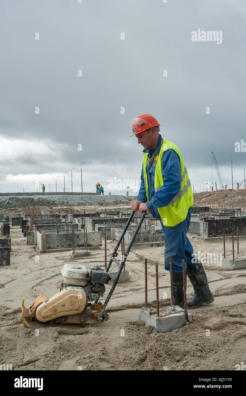 Builder worker with vibration plate Stock Photo - Alamy