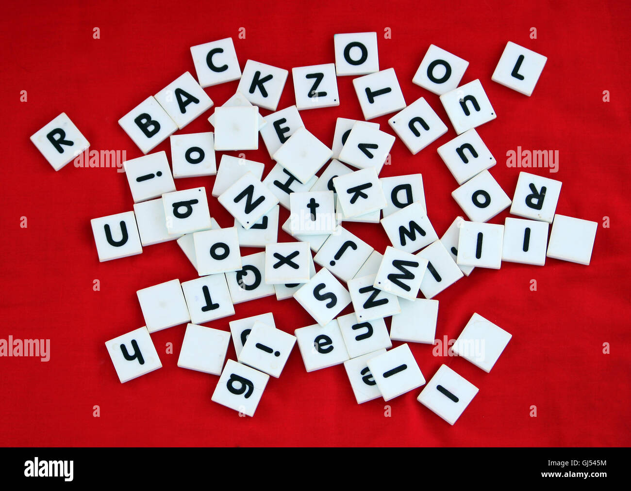 Letter tiles scattered over red background Stock Photo - Alamy