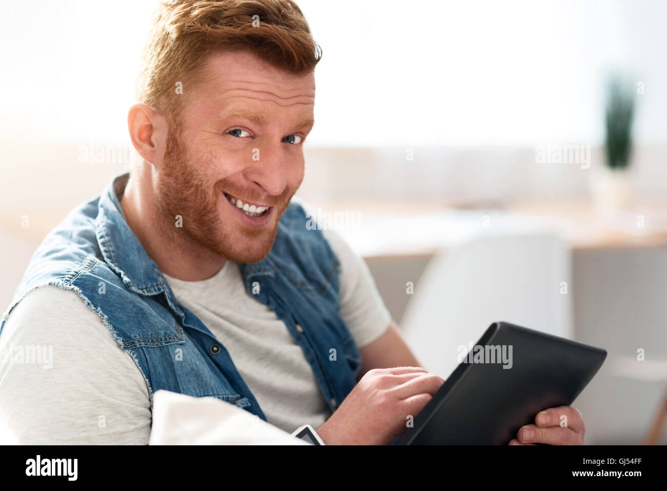 Joyful man using tablet Stock Photo - Alamy