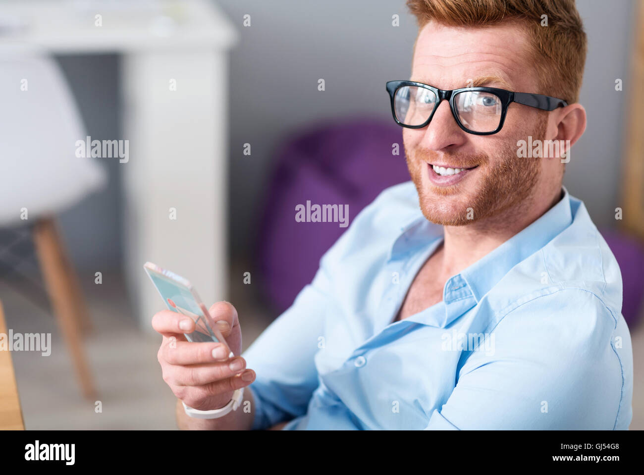 Joyful handsome man holding cell phone Stock Photo - Alamy