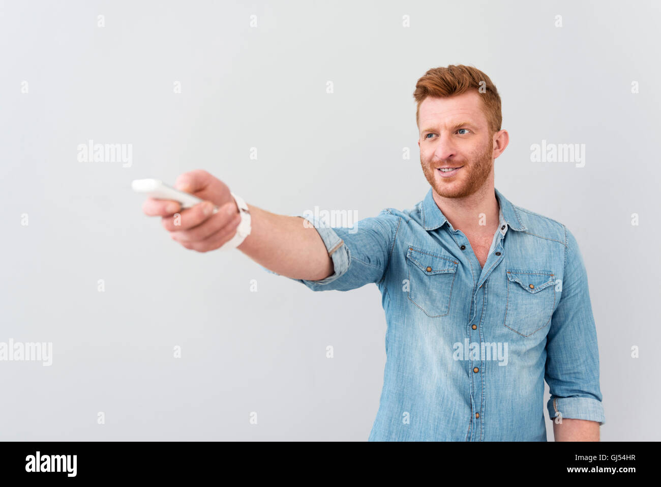 Positive man holding remote control Stock Photo - Alamy