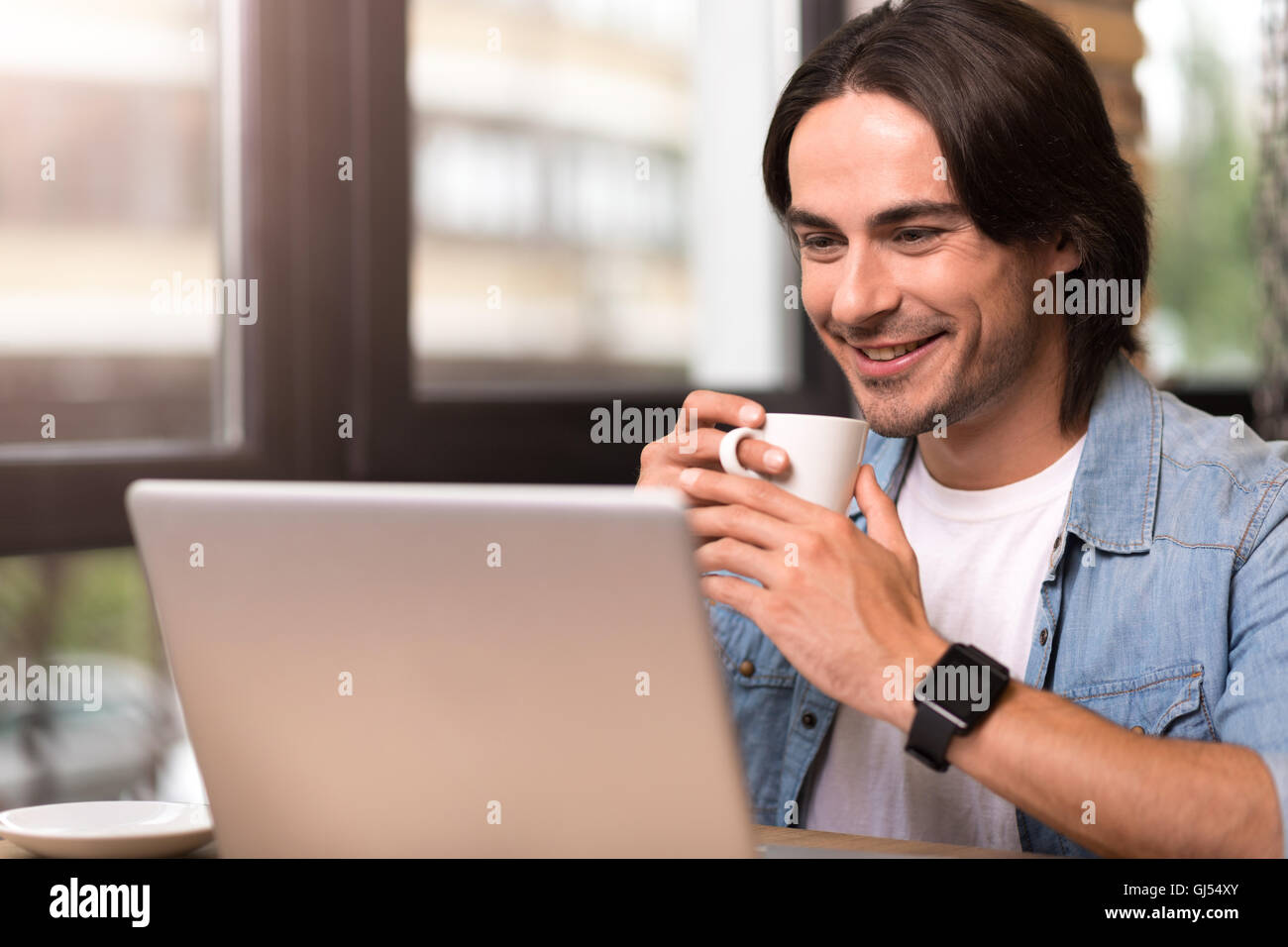 Delighted smiling man drinking coffee Stock Photo - Alamy