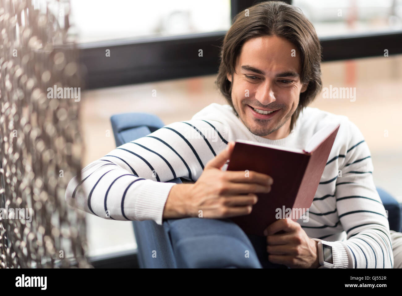 Cheerful man reading a book Stock Photo - Alamy