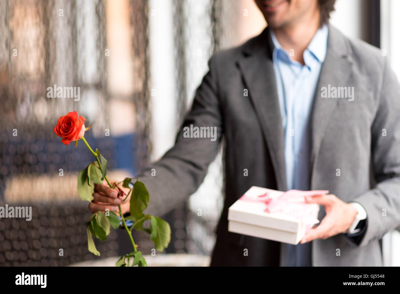 Positive man holding present Stock Photo - Alamy
