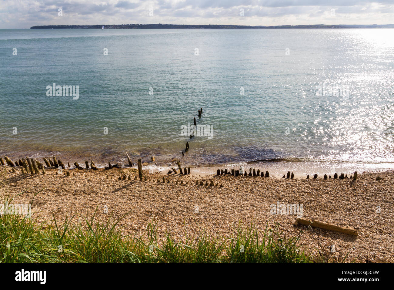Pebble beach with worn defences and Isle of Wight in distance. Lepe ...