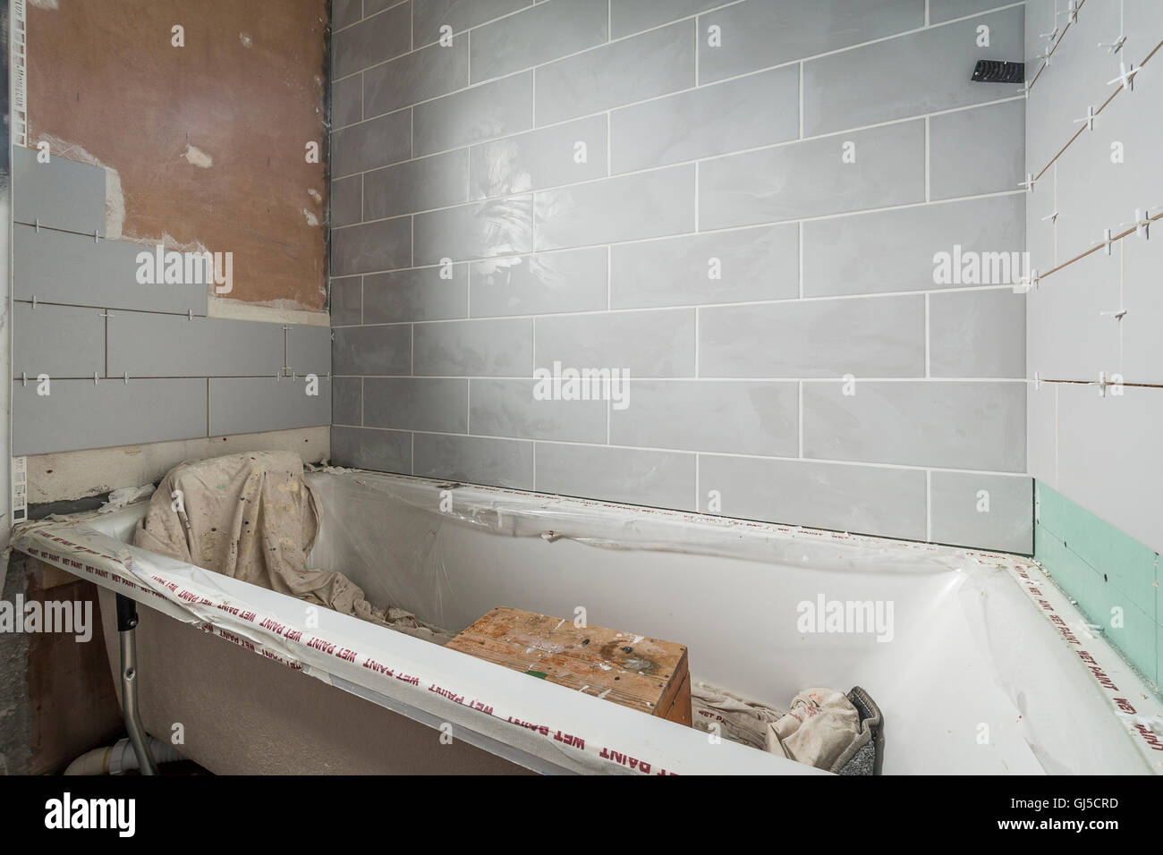 Halfway through tiling in a new bathroom Stock Photo - Alamy