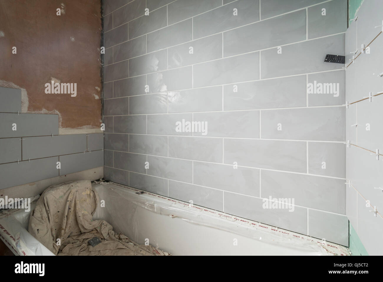 Halfway through tiling in a new bathroom Stock Photo - Alamy