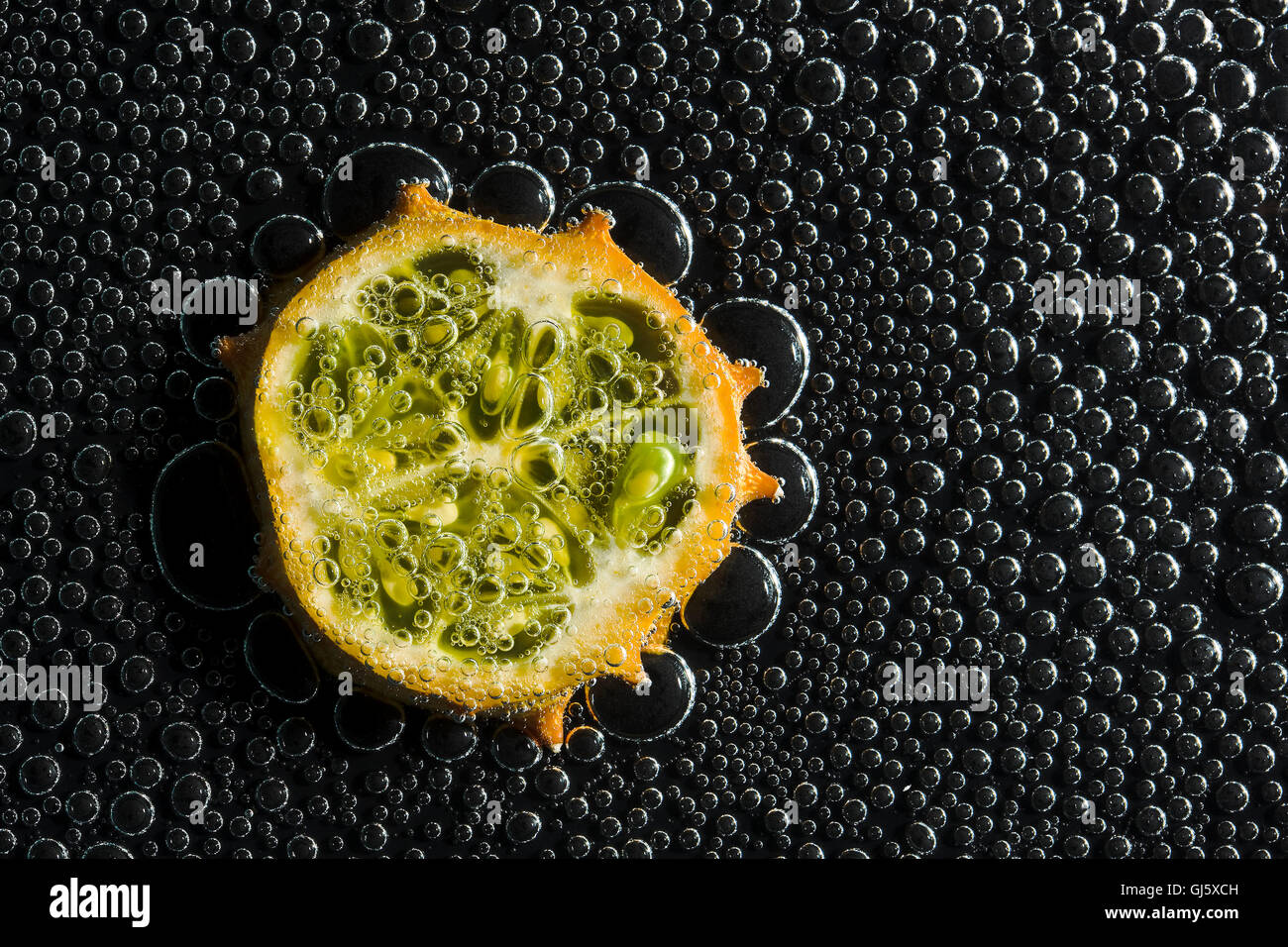 Kiwano fruit in mineral water, a series of photos. Close-up carbonated ...