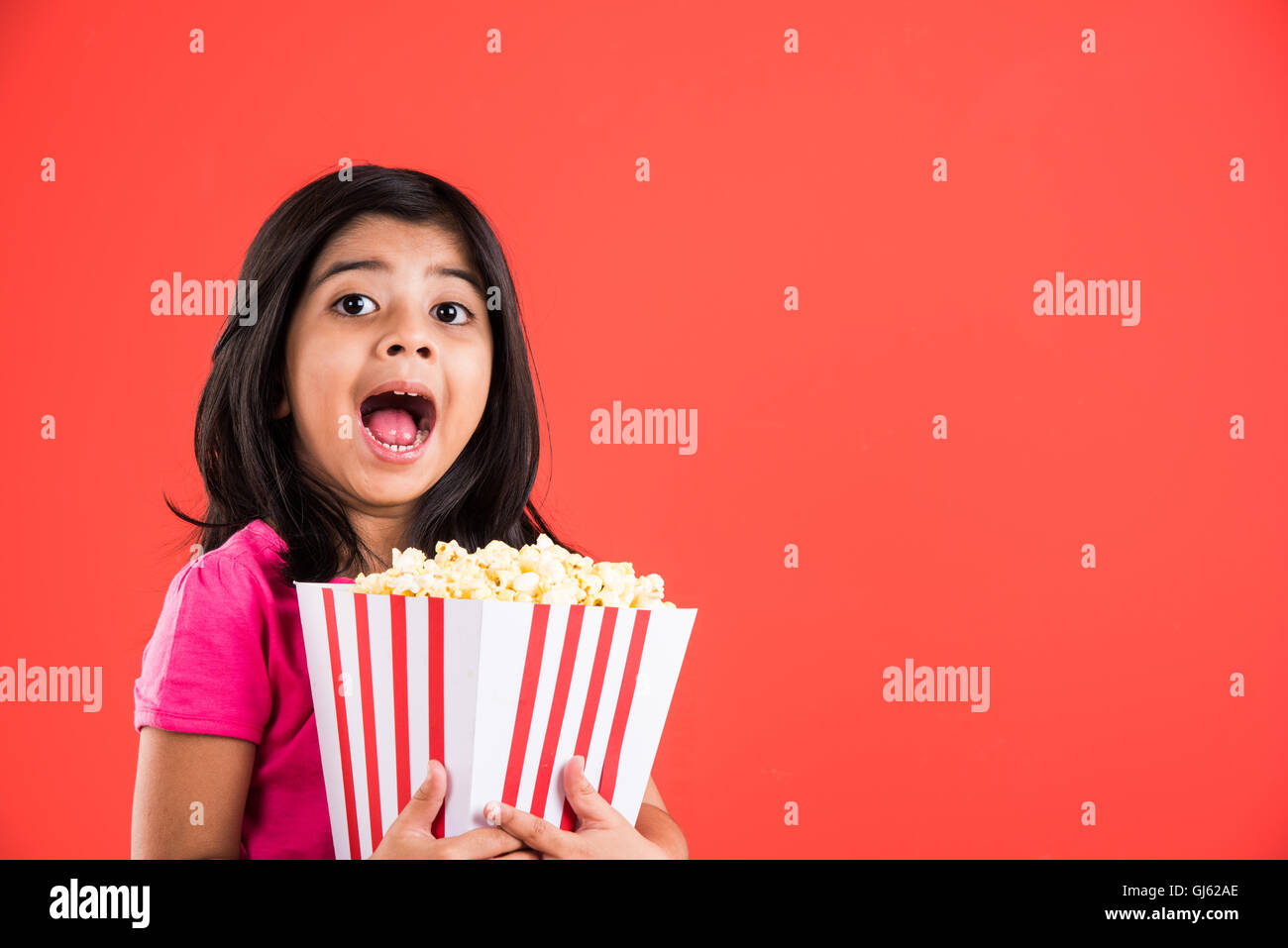 happy girl eating popcorn, indian girl eating popcorn, asian girl and ...