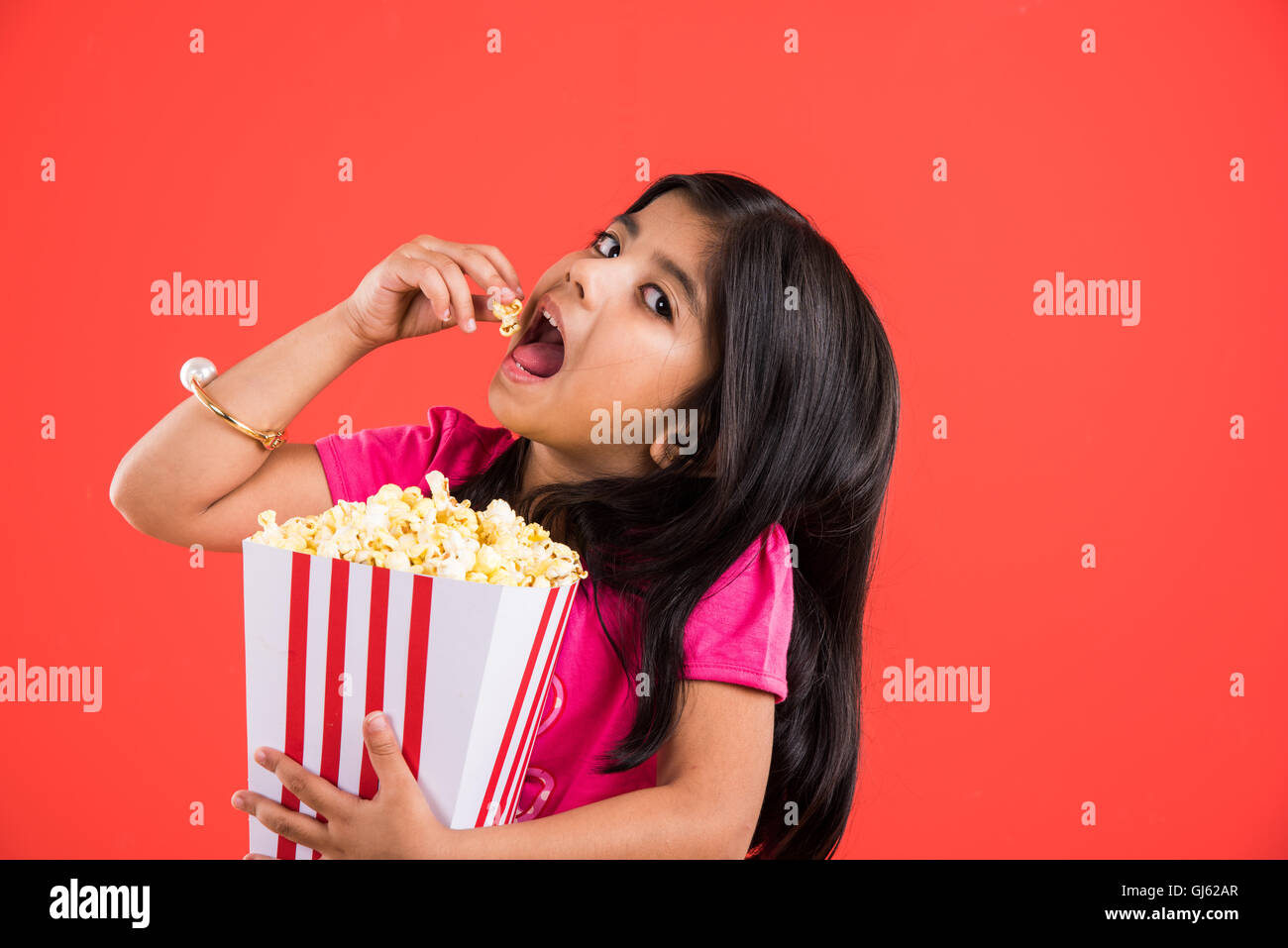 happy girl eating popcorn, indian girl eating popcorn, asian girl and ...
