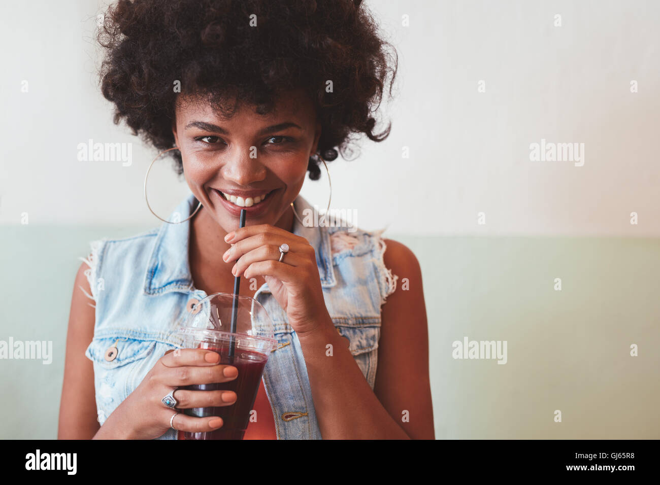 Close up shot of young african woman enjoying a fresh fruit juice ...
