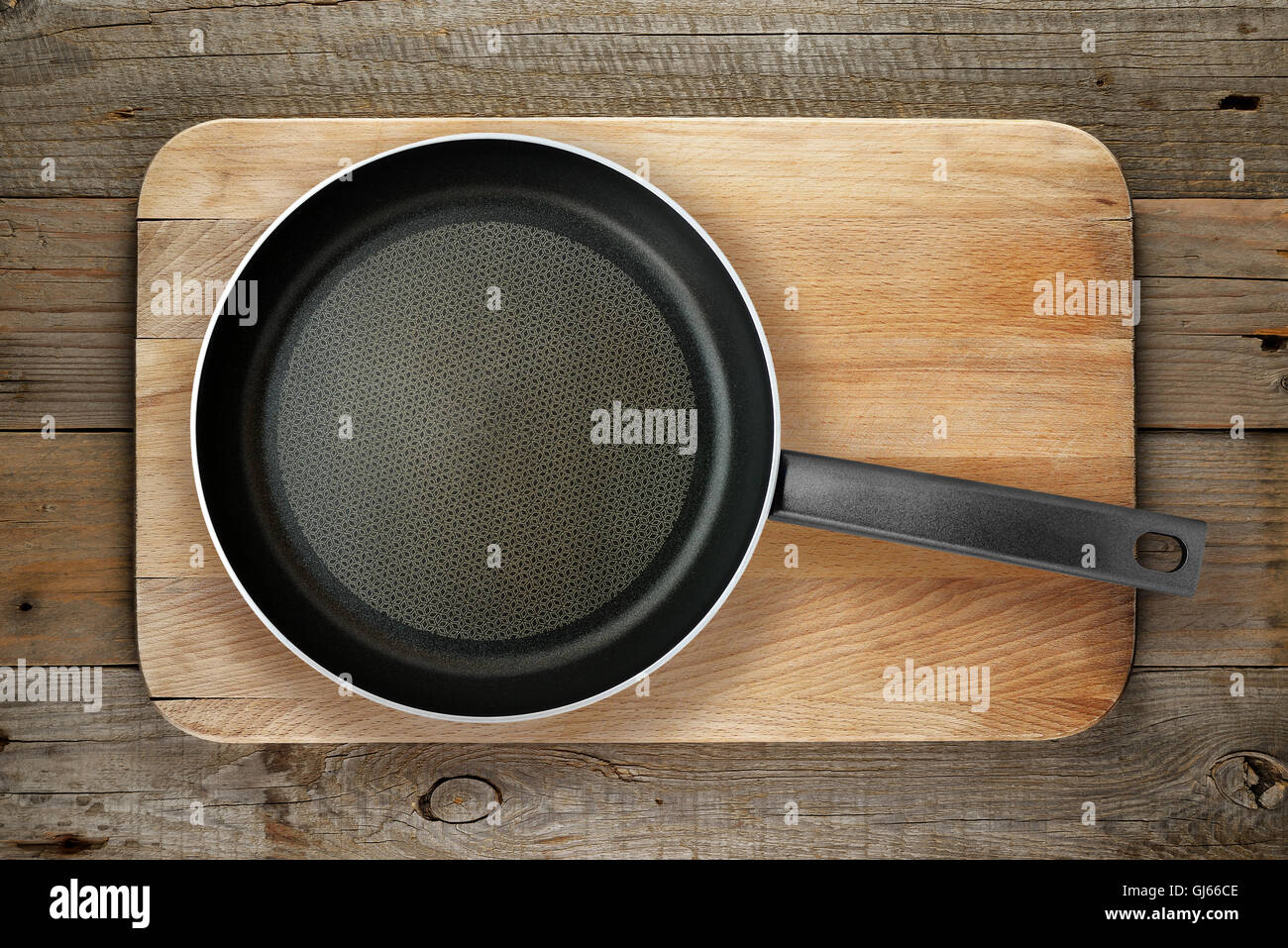 Empty frying pan on chopping board top view Stock Photo - Alamy