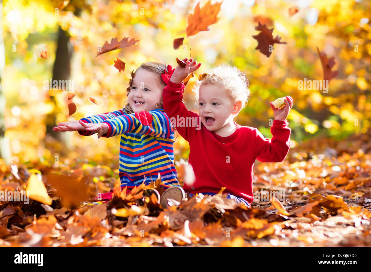 Happy children playing in beautiful autumn park on warm sunny fall day ...