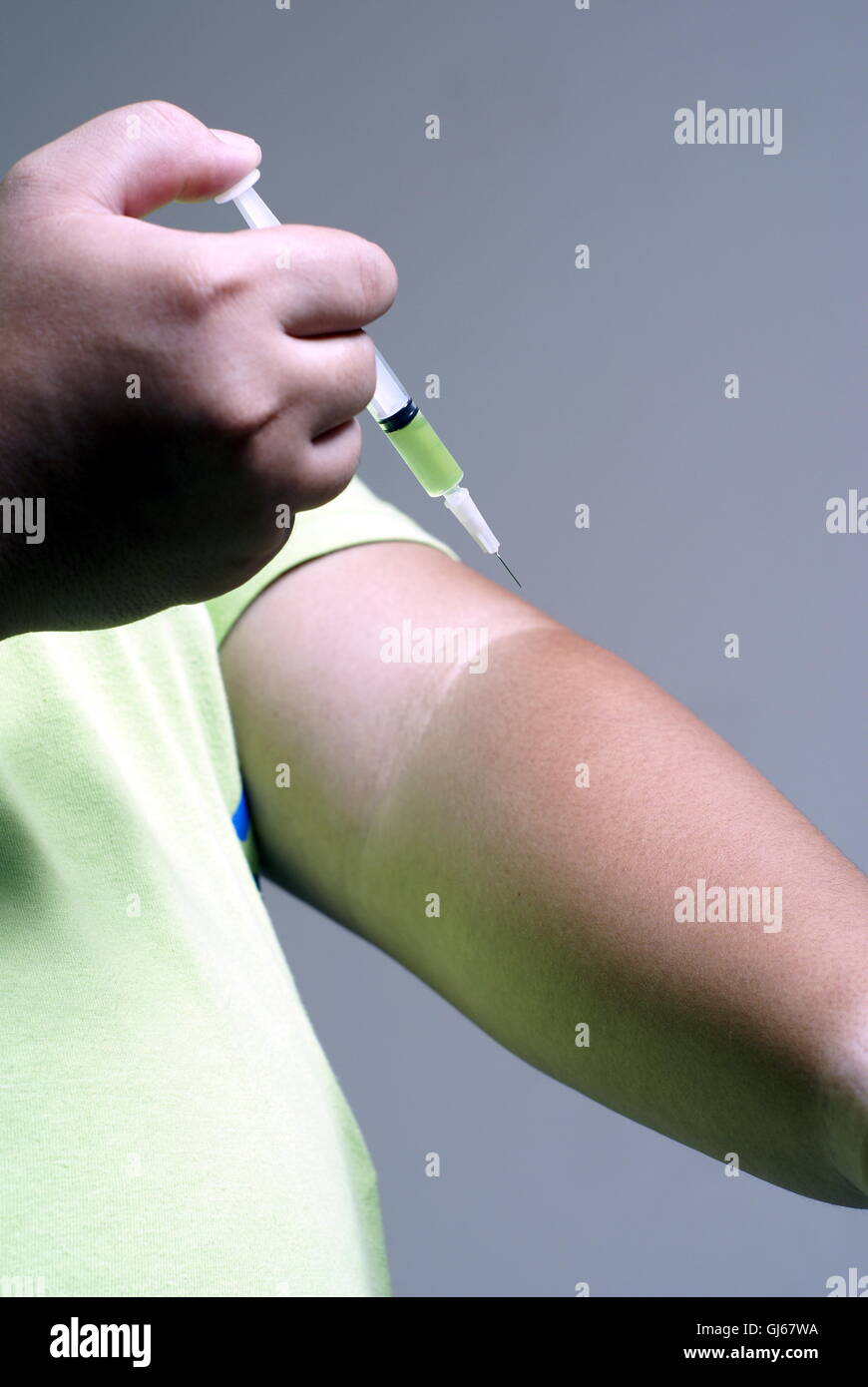 Arm injection using syringe with green liquid Stock Photo - Alamy