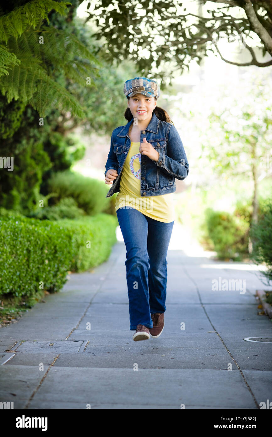 Tween Girl Running On Sidewalk Stock Photo - Alamy