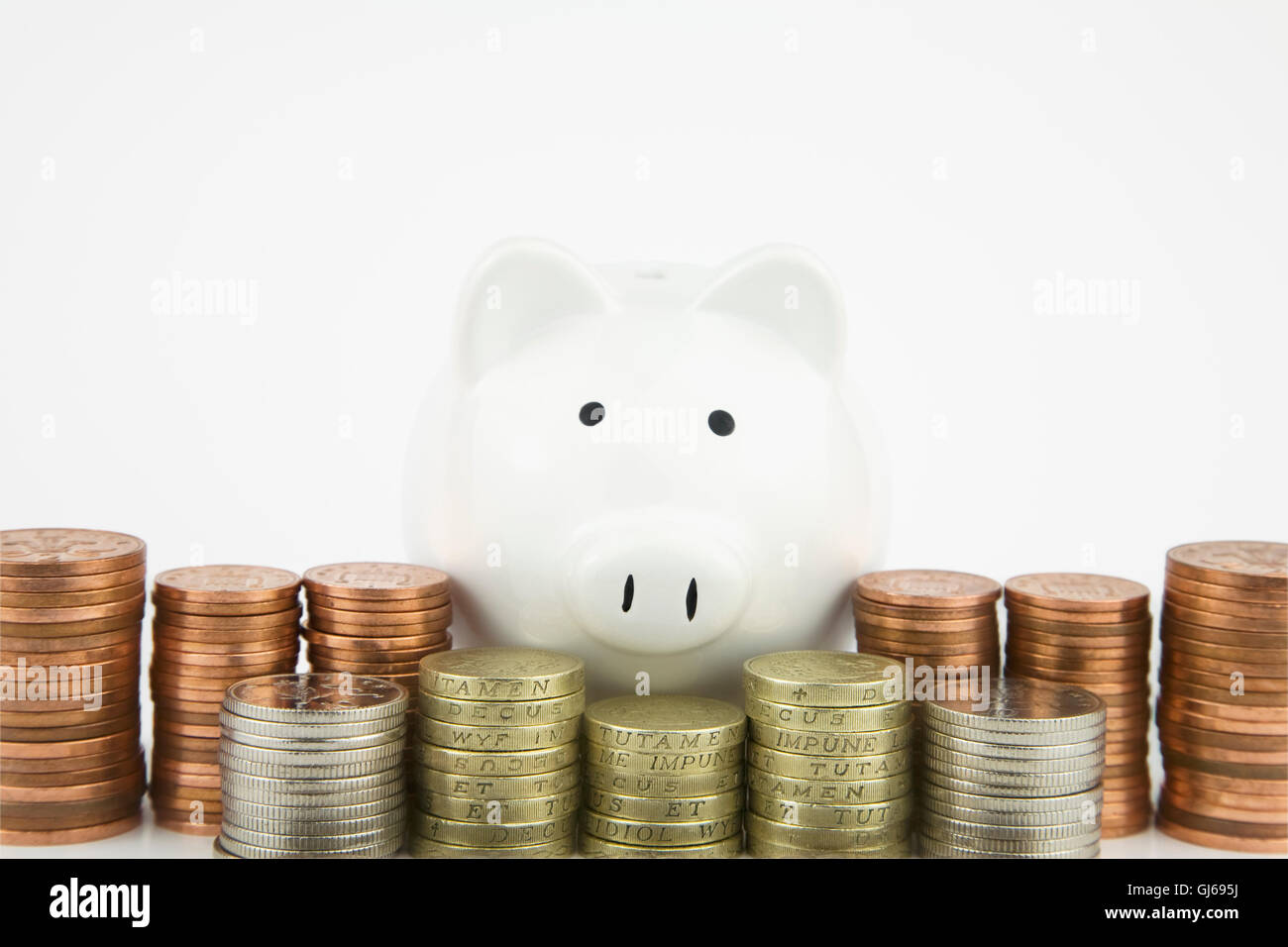 White Piggy bank With British Coins Stock Photo - Alamy