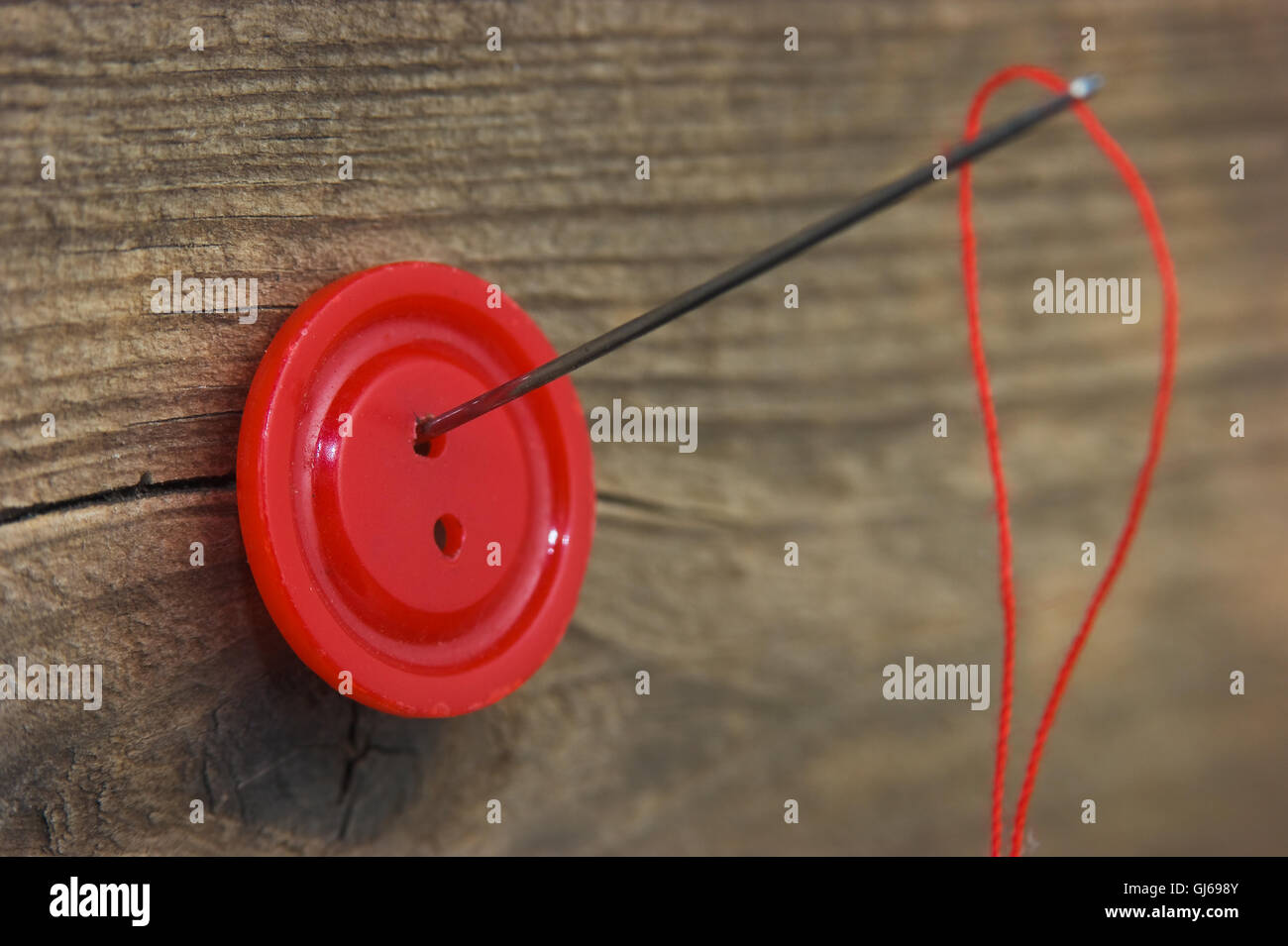 Buttons with needle and thread Stock Photo - Alamy