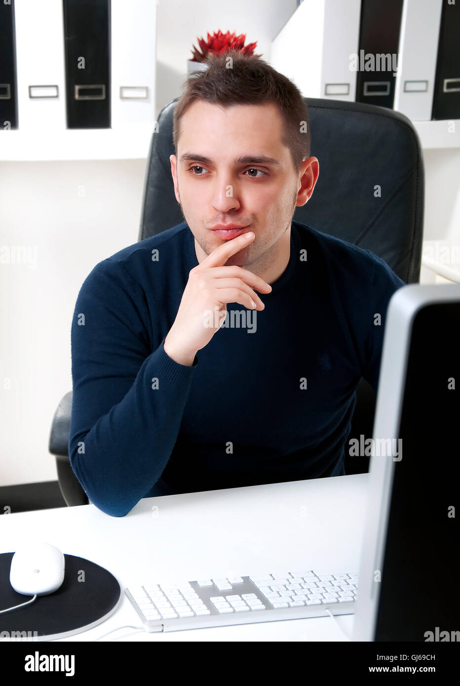 Young man thinking in front of his computer Stock Photo - Alamy