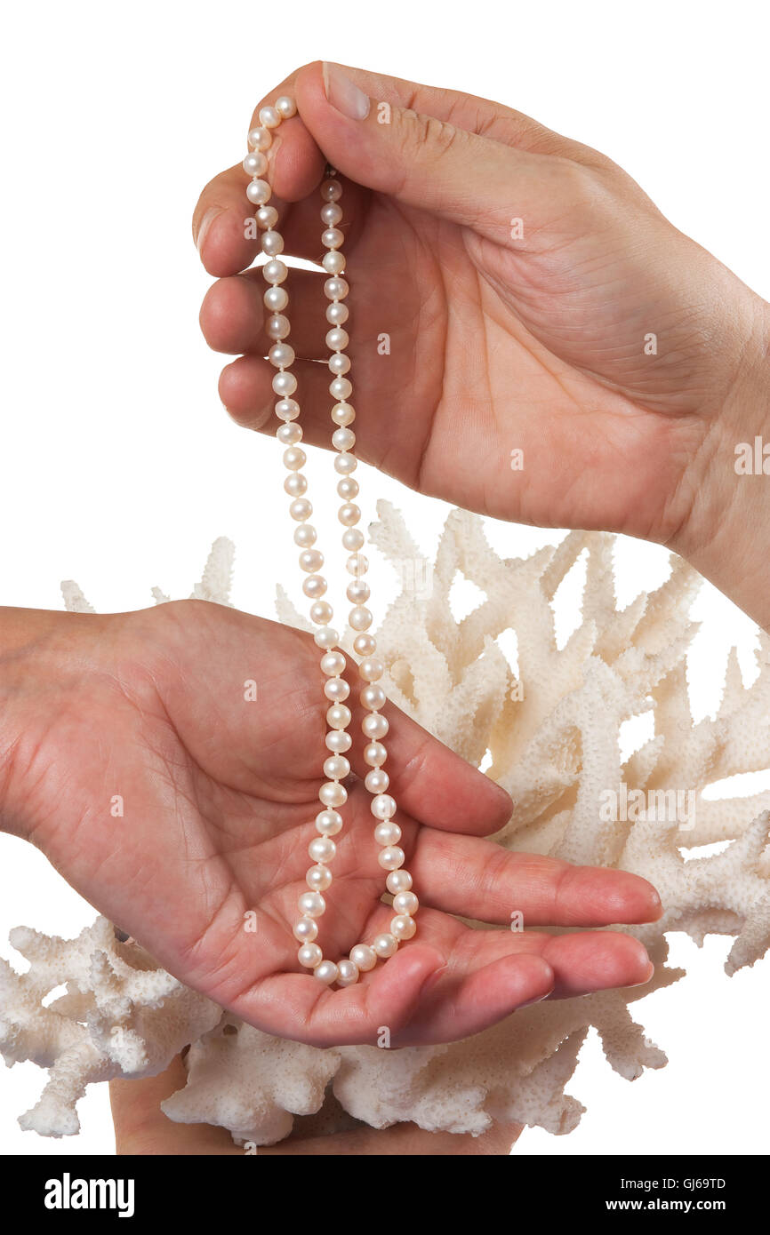 a pearl necklace in her hands against the backdrop of coral Stock Photo ...