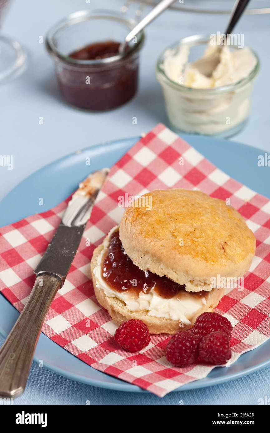 Scone with clotted cream and raspberry jam Stock Photo - Alamy