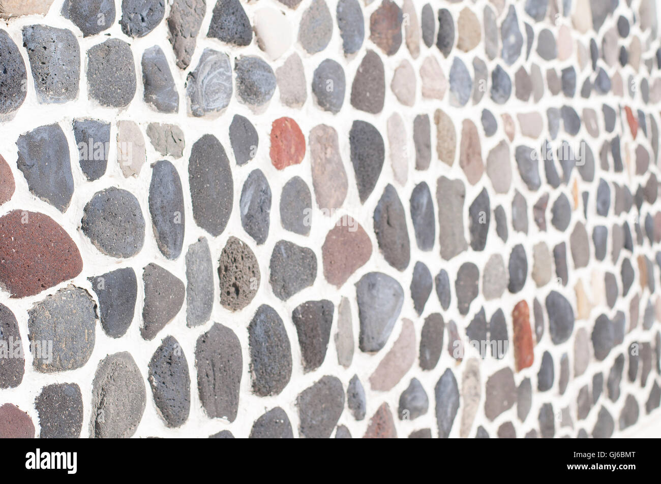 view to stone wall made of volcanic stones, Oia, Santorini, Greece ...