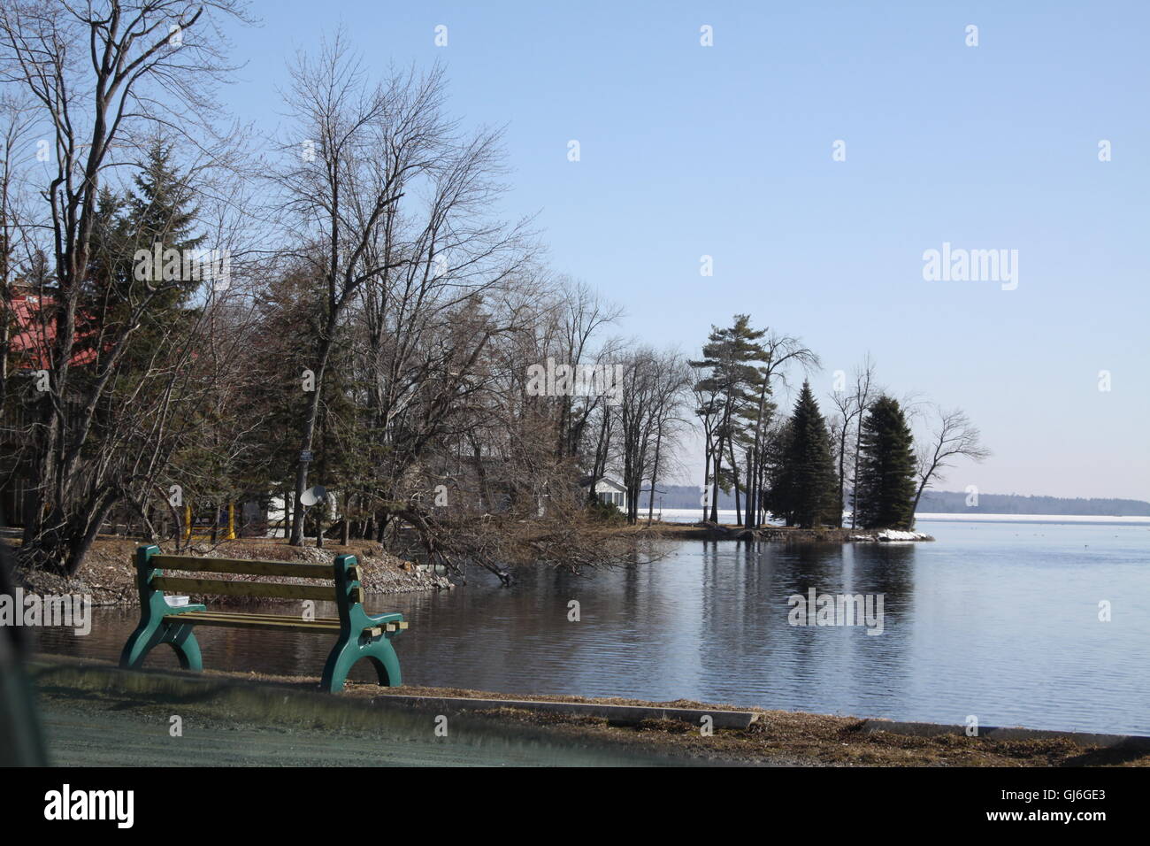 A small peninsula of land with trees jutting out into a small lake ...