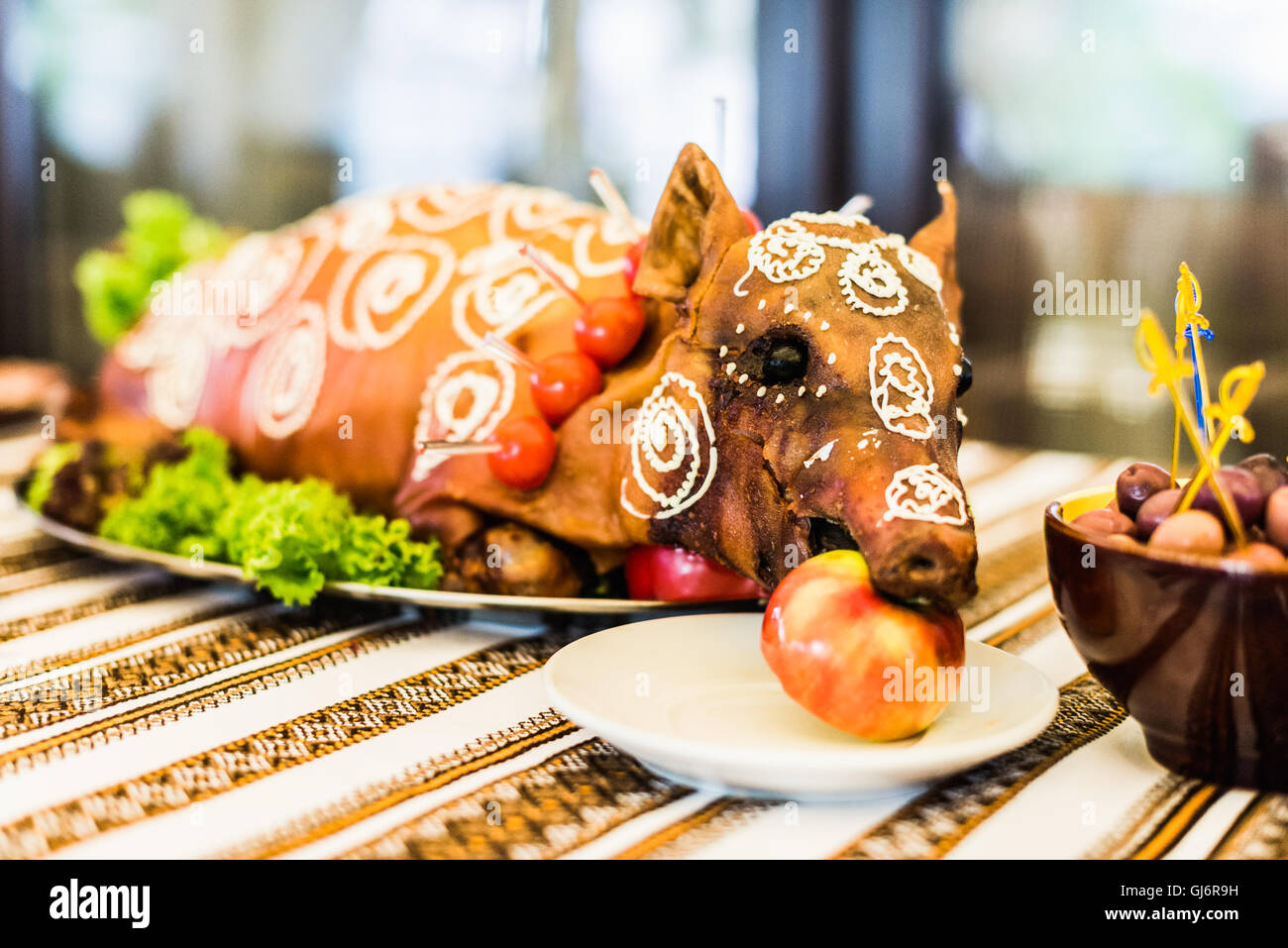 Decorated and roast suckling pig with an apple in his mouth on a white ...