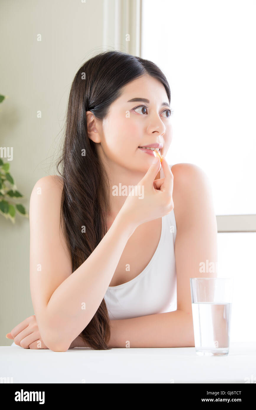 beautiful asian women eating nutritional fish oil supplement for ...