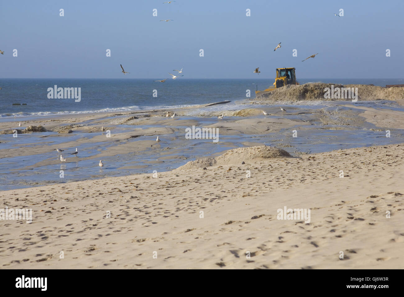 Sand replenishment at the red cliff Stock Photo - Alamy