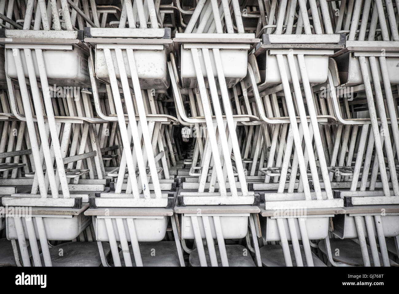 Stacked up school desks Stock Photo - Alamy