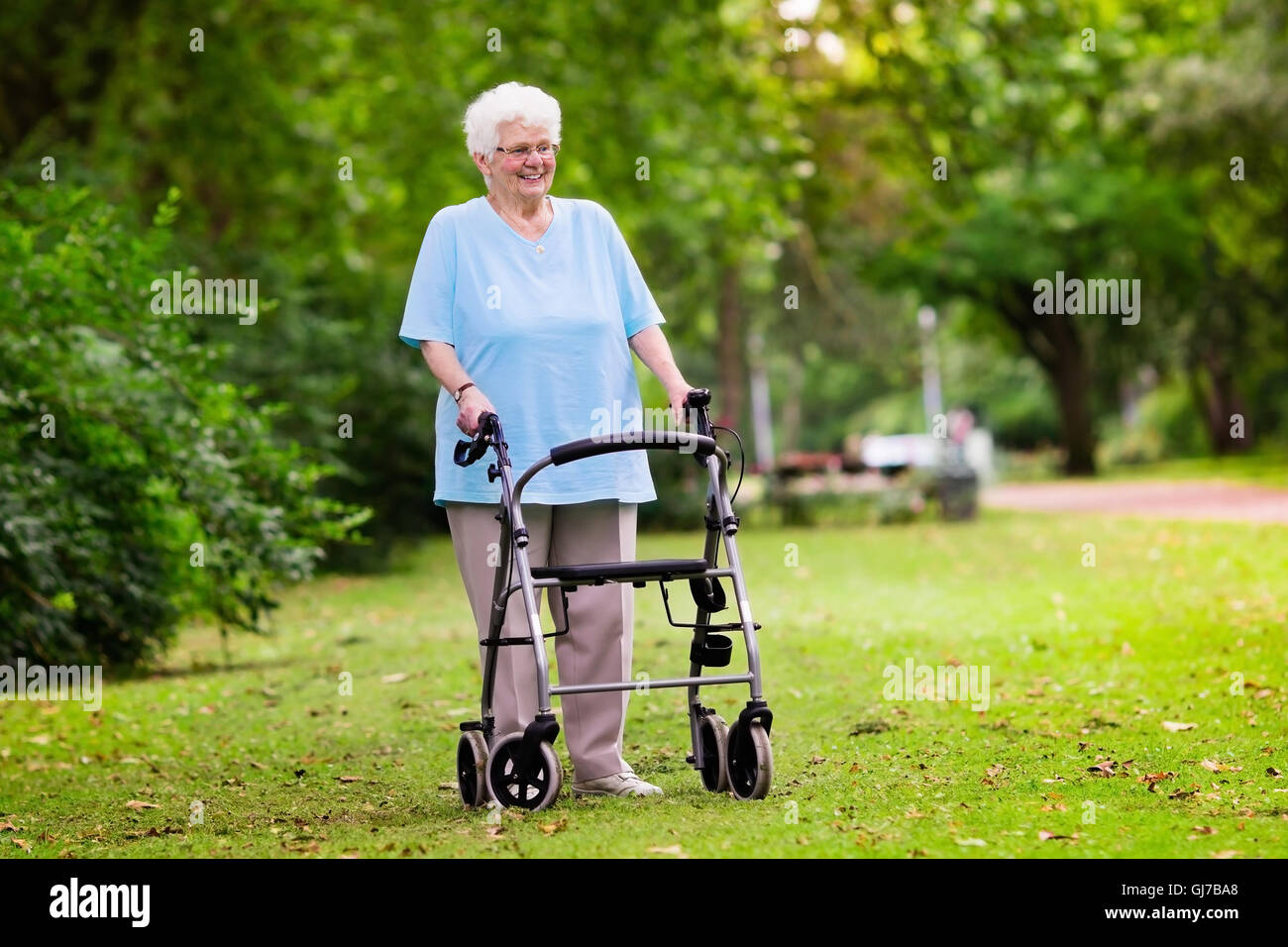 Happy senior handicapped lady with a walking disability enjoying a walk ...