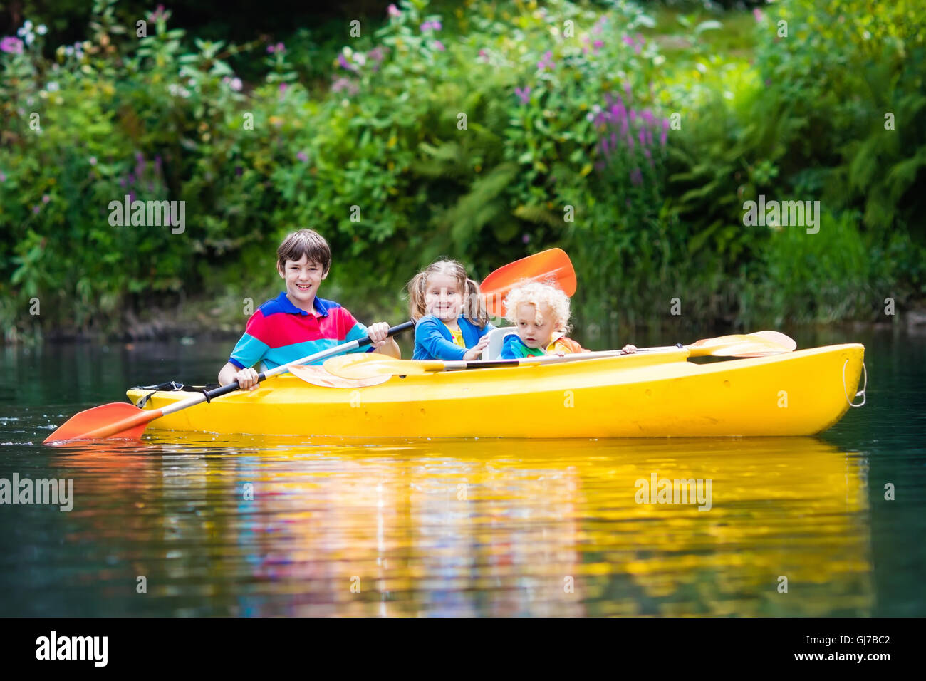 Happy family with three kids enjoying kayak ride on beautiful river ...