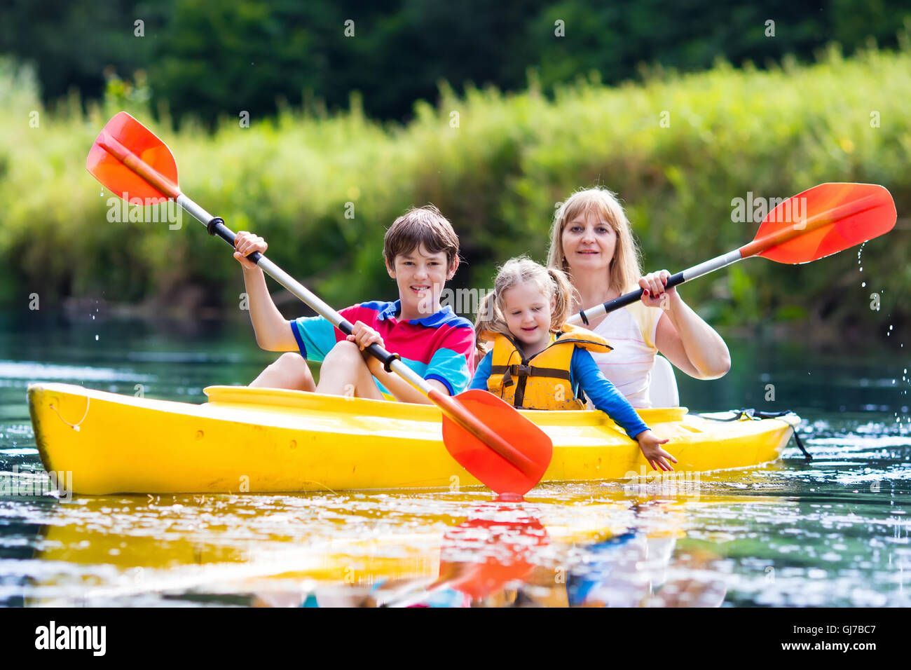 Happy family with two kids enjoying kayak ride on beautiful river ...