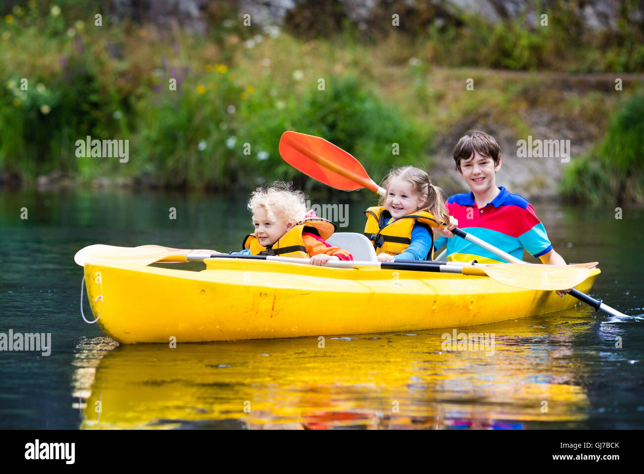 Happy family with three kids enjoying kayak ride on beautiful river ...