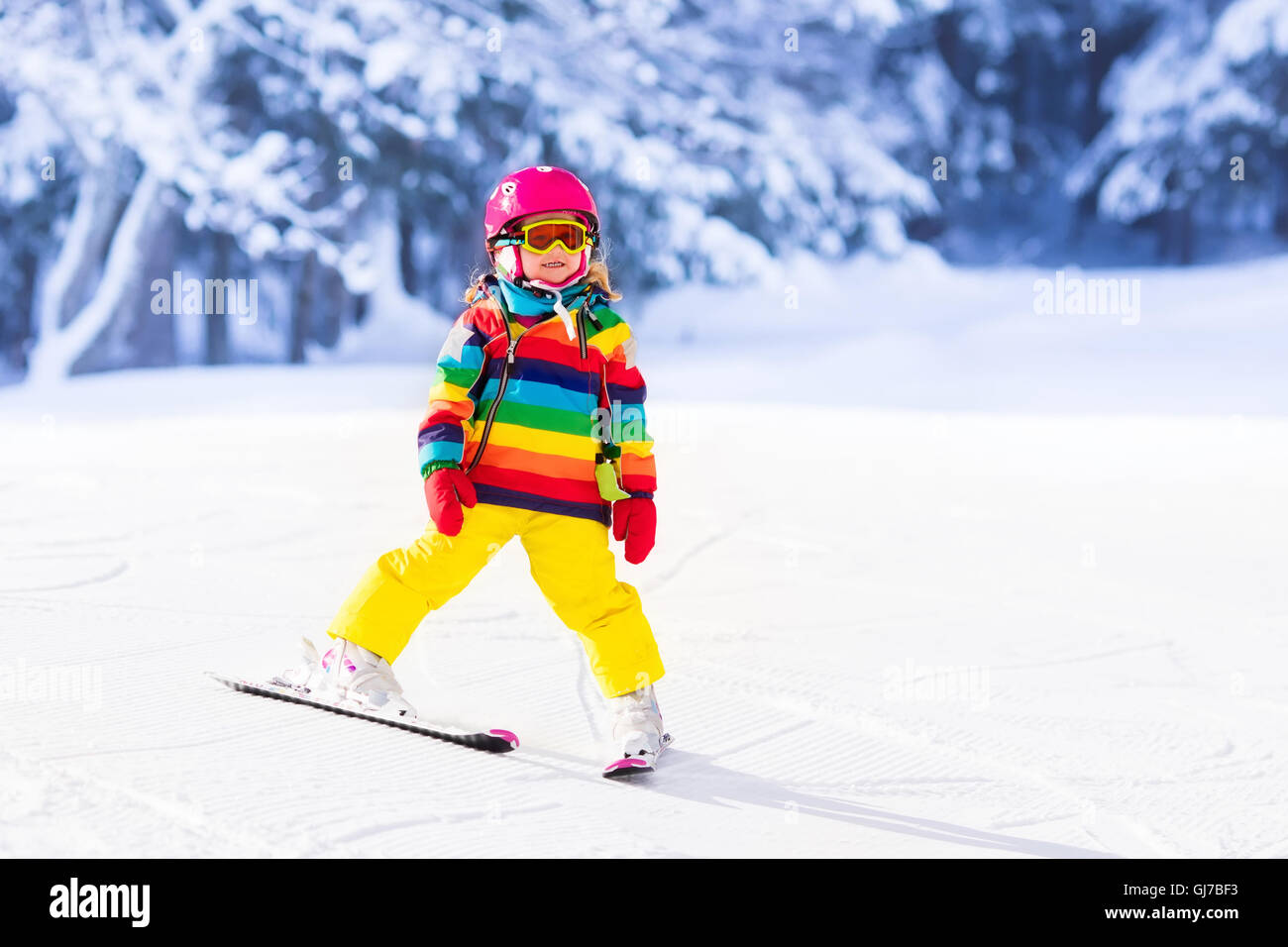 Child skiing in mountains. Active toddler kid with safety helmet ...