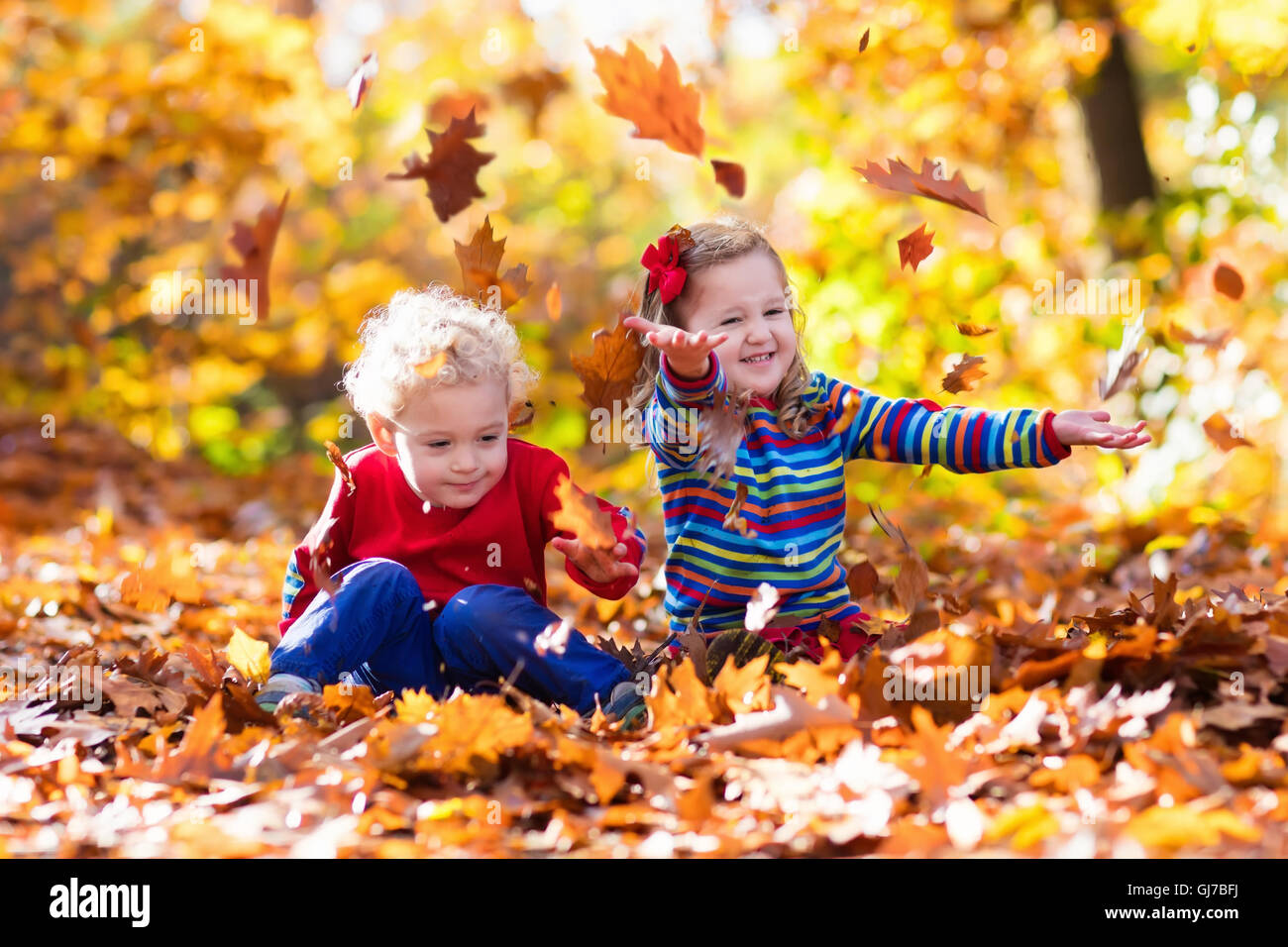 Happy children playing in beautiful autumn park on warm sunny fall day ...