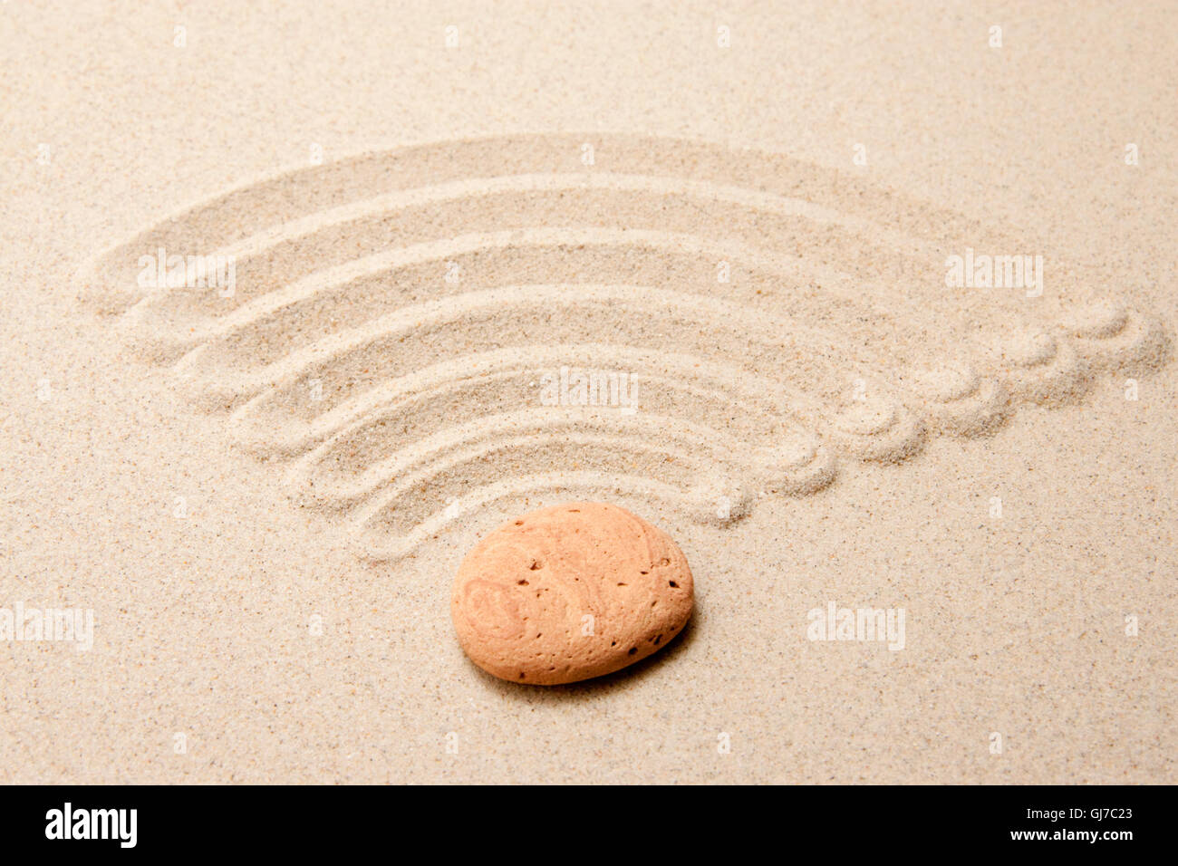 Symmetric lines in the sand with flat round sand stone Stock Photo - Alamy