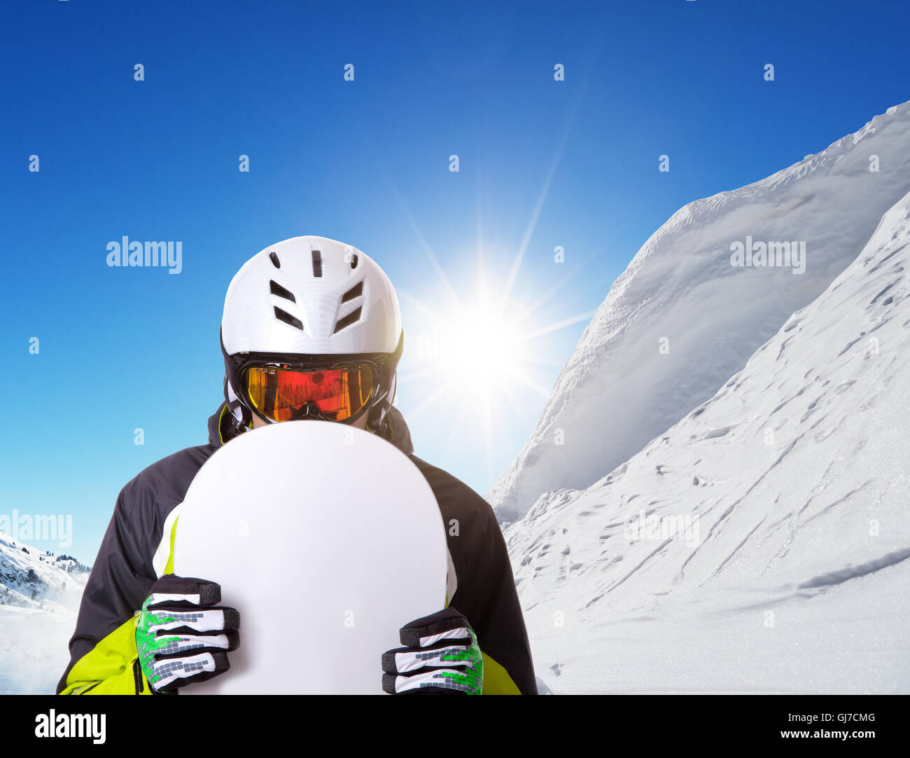 Snowboarder holding his snowboard off piste, beautiful winter landscape ...