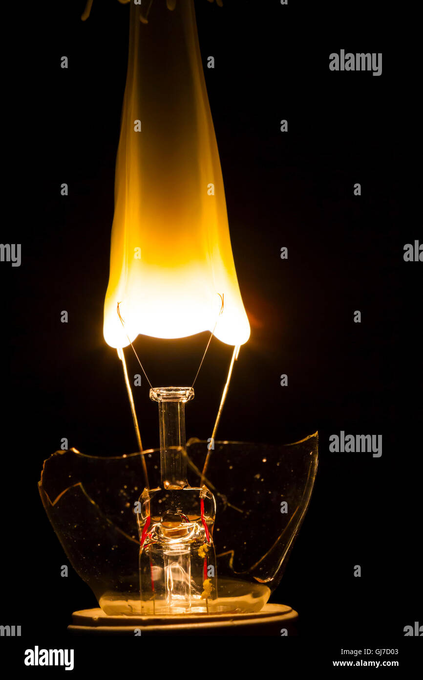 Broken lightbulb with it's filament combusting as it is exposed to the ...