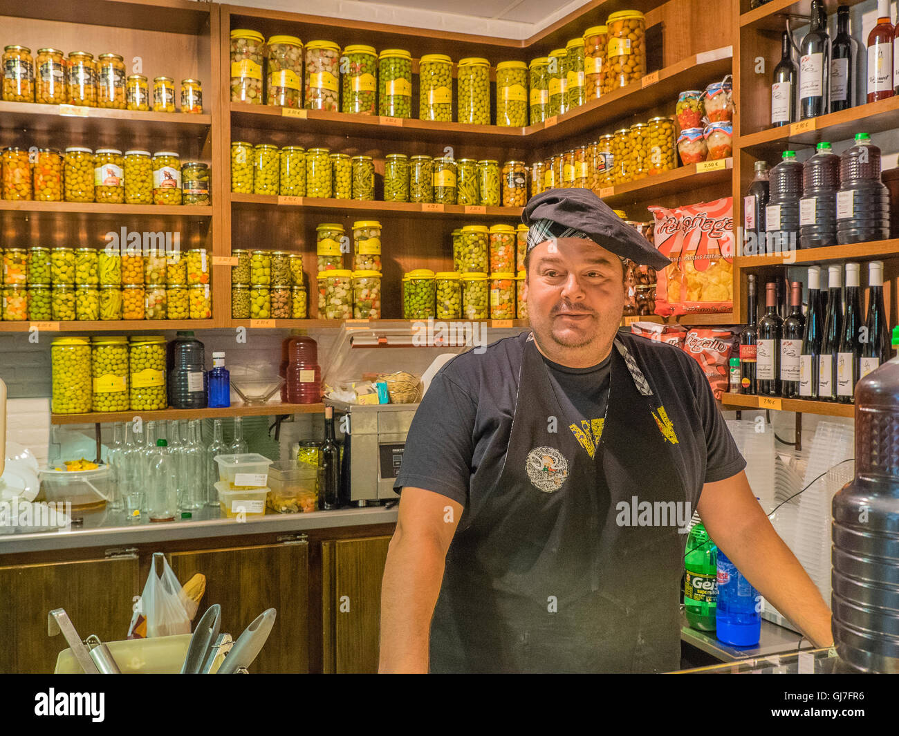 A male Spanish olive merchant stands at his stall in the Mercado San ...